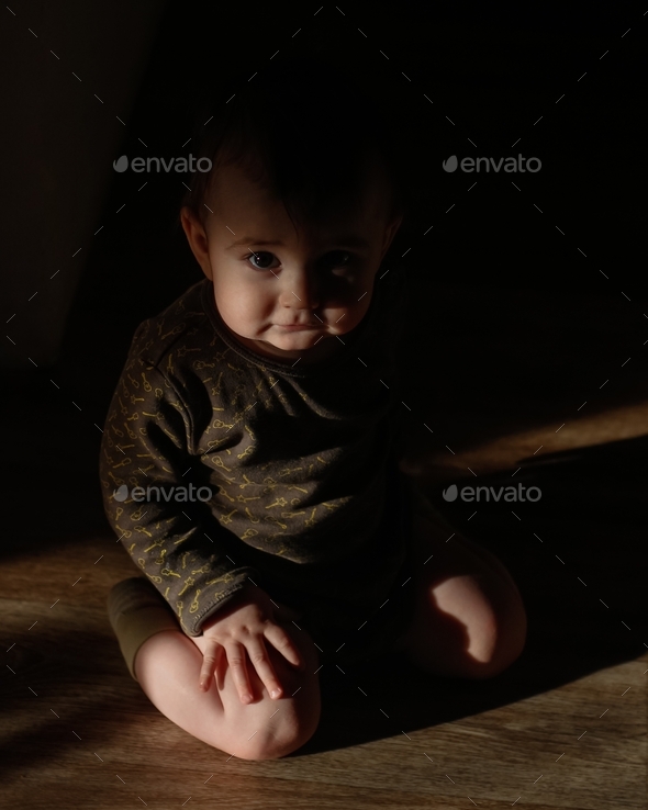 Cute kid looks at the camera. Light and shadow Stock Photo by ElenNika
