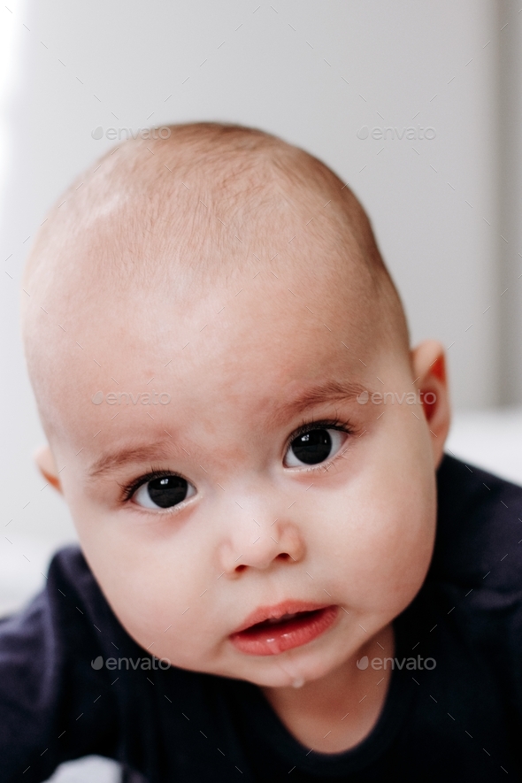 Sweet chubby cheeky baby boy lying on his tummy on the bed. Stock Photo ...