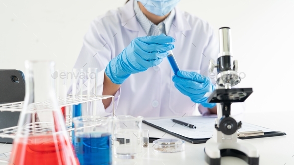 scientists researching in laboratory in white lab coat, gloves ...