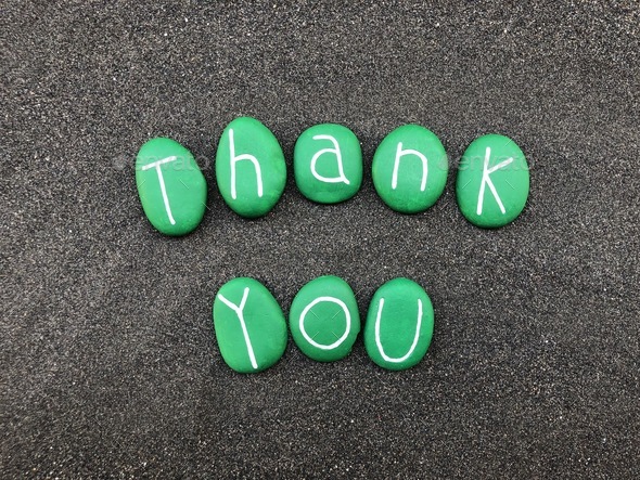 Thank you text composed with green colored stone letters over black ...