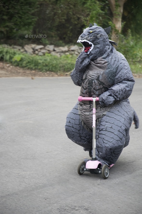 Child in a Godzilla Costume Riding a Scooter Stock Photo by ...