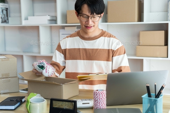 the salesperson reading the product list while packing the product into ...