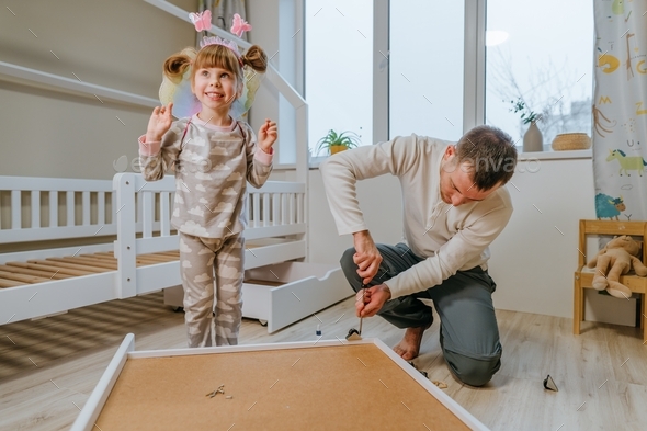 Daddy and daughter having fun time assemble furniture using screw to ...