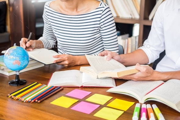 Young students classmates help friend catching up workbook and learning ...