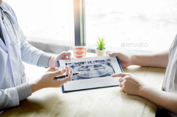 Dental hygienist demonstrating and showing a dummy jaw to check-up or ...