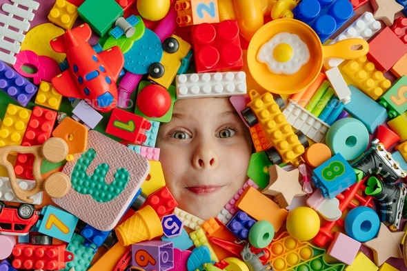 Little girl lying in the mess of toys. Top view, flat lay. Stock Photo ...