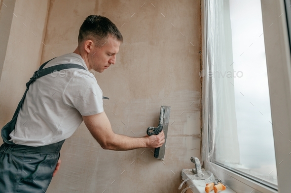 Worker applying putty mortar on the balcony wall Stock Photo by ...
