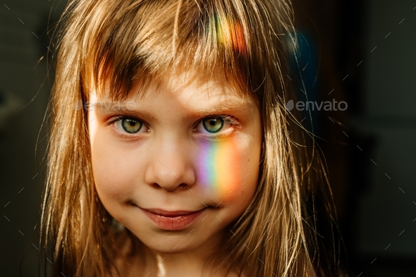Little girl with rainbow light on the face Stock Photo by lithiumphoto