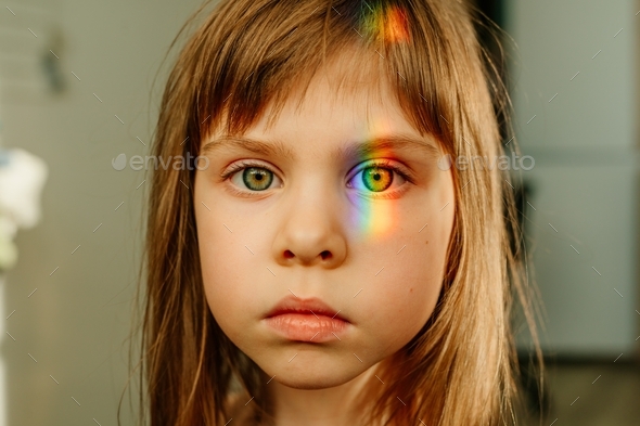 Little girl with rainbow light on the face Stock Photo by lithiumphoto