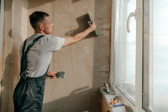 Worker applying putty mortar on the balcony wall Stock Photo by ...