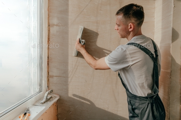 Worker applying putty mortar on the balcony wall Stock Photo by ...