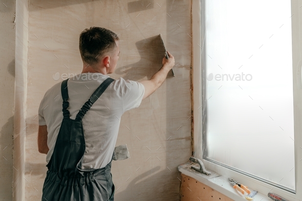 Worker applying putty mortar on the balcony wall Stock Photo by ...