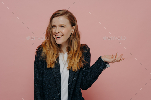 Laughing young woman with tipping hand shrugging shoulders Stock Photo ...