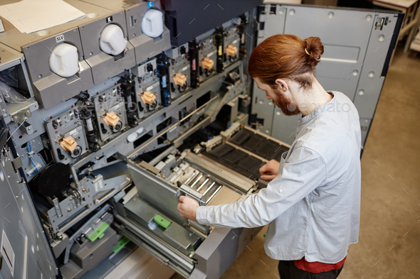 Worker Using Printing Machine Top View Stock Photo by seventyfourimages
