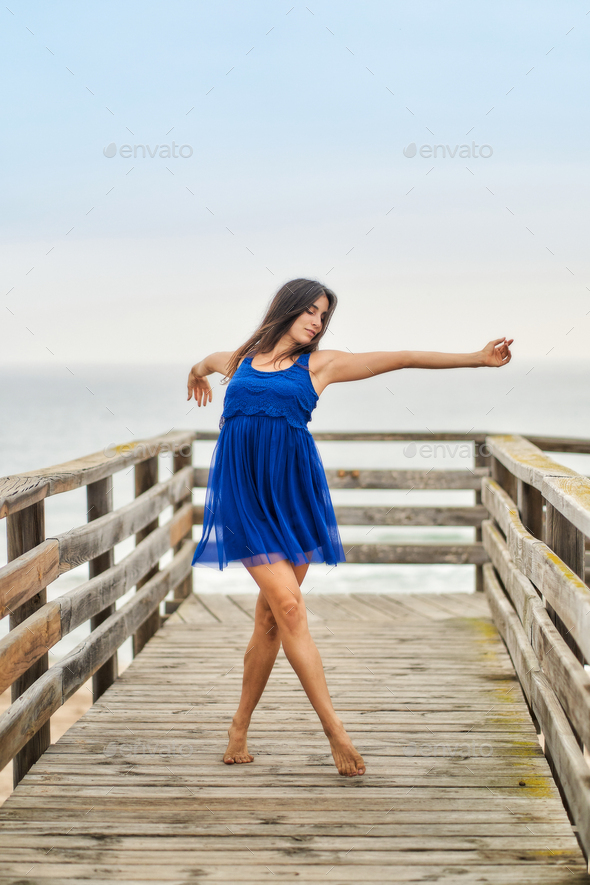 a dancer in a blue dress on the beach catwalk performing contemporary ...
