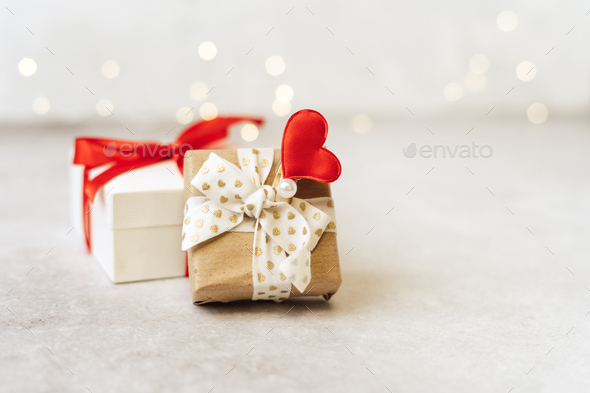 Gift or present box with red bow and heart shape on lights background ...