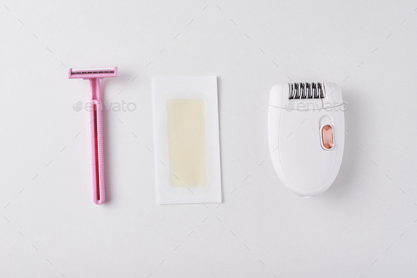 Epilator, razor and wax strips on white background Stock Photo by Lazy_Bear