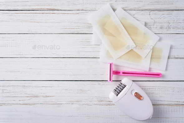 Epilator, razor and wax strips on white background Stock Photo by Lazy_Bear