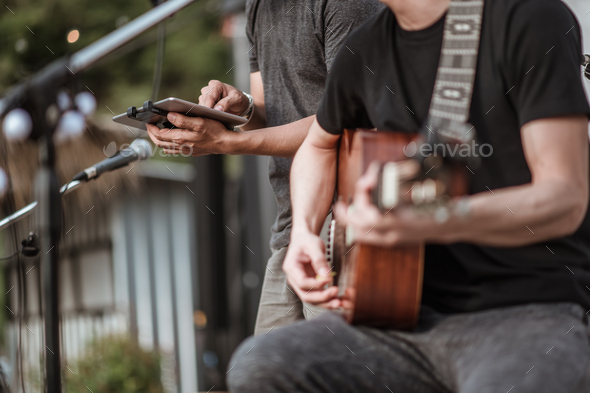 The musicians are checking the sound of the guitar and trying to play ...
