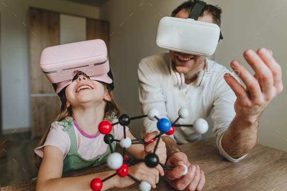 Little girl having fun time with her father using VR glasses Stock ...