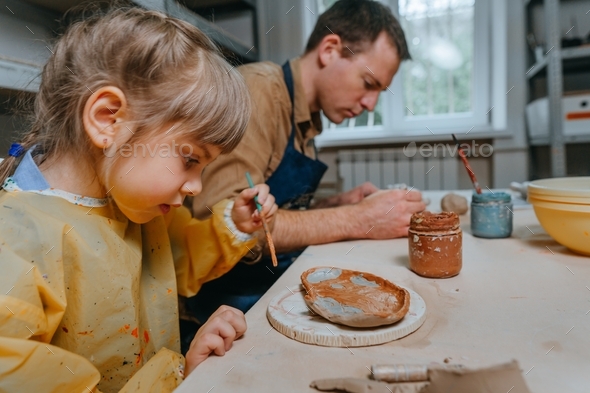 Father and his daughter at a master class in clay modeling Stock Photo ...