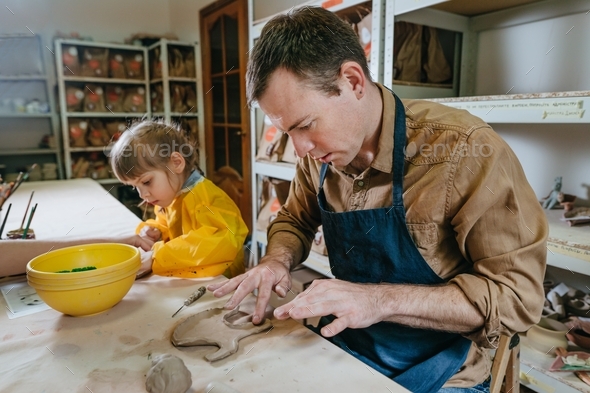 Father and his daughter at a master class in clay modeling Stock Photo ...