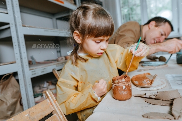Father and his daughter at a master class in clay modeling Stock Photo ...