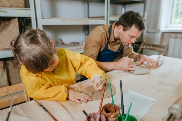 Father and his daughter at a master class in clay modeling Stock Photo ...