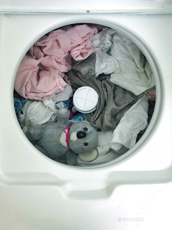 Washing machine loaded with clothes to wash Stock Photo by globetrotter_