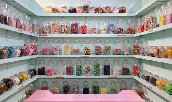Colourful candy jars on shelves against pink background Stock Photo by ...