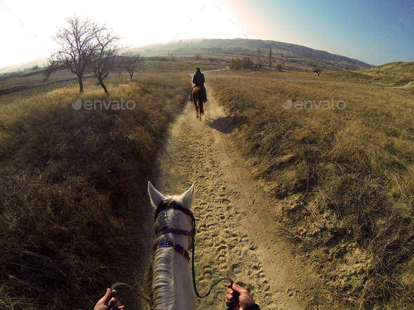 First person point of view of a guy horse riding in the desert valleys ...