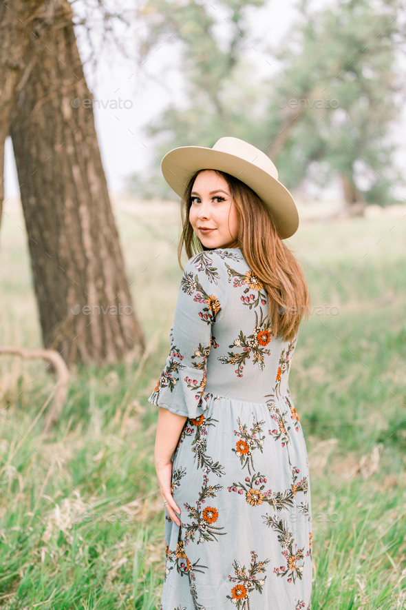 Portrait of Beautiful young woman looking back at camera in a park ...