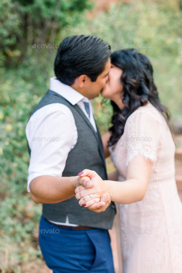 Newly engaged couple share a kiss white holding hands Stock Photo by ...