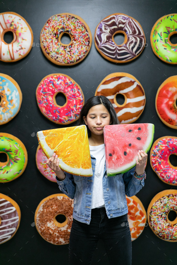 Girl in front on a donut decorated wall Stock Photo by takemewu31