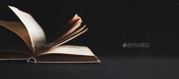 Open book with pages on a black background. Stock Photo by rstavila1