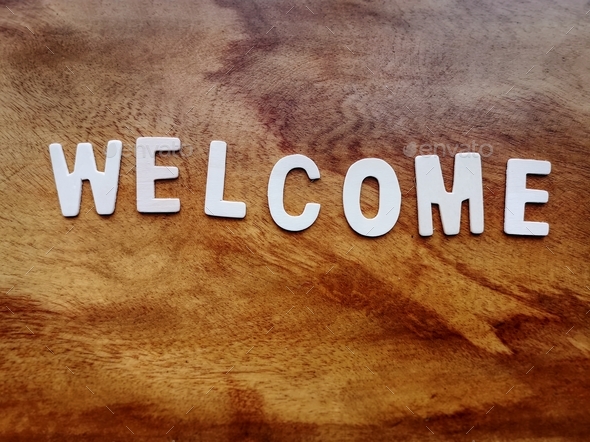 White Welcome Text on Wooden Table Background Stock Photo by akedynamic