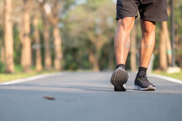 fitness man legs walking in the park outdoor. male runner running on ...