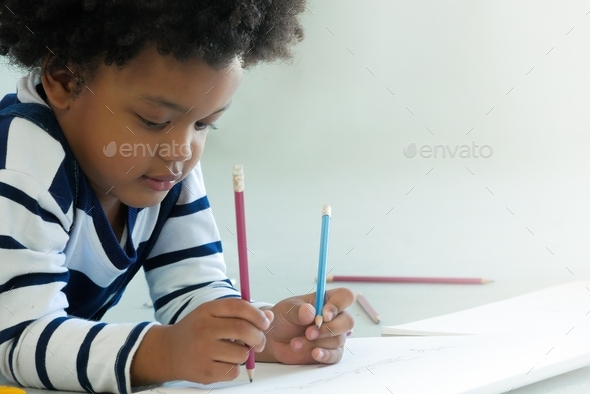 Little african boy writing in room Stock Photo by Thaitoystory | PhotoDune