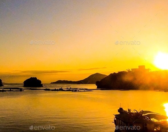 Morning sun rising behind the coastal mountain Stock Photo by MayFayStudio