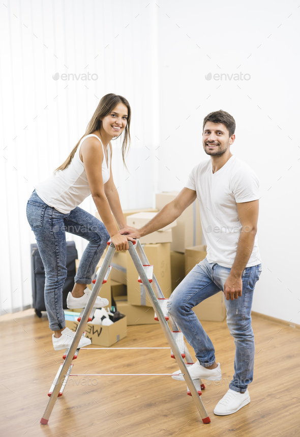 The happy couple stand on the ladder on the background of the carton ...