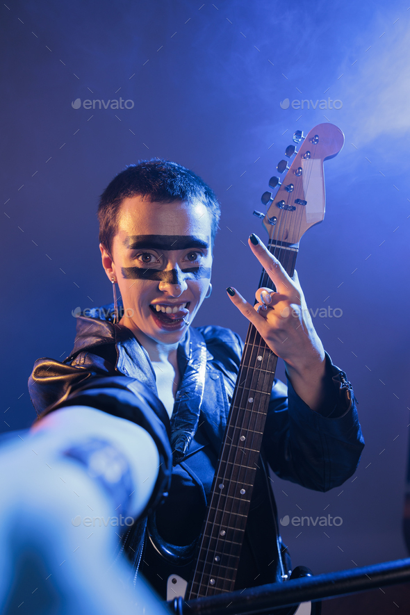 Punk rocker sticking tongue out doing rock sign Stock Photo by DC_Studio