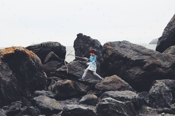 Boy jumping on rocks, nature, ocean scene. Stock Photo by wdnesday