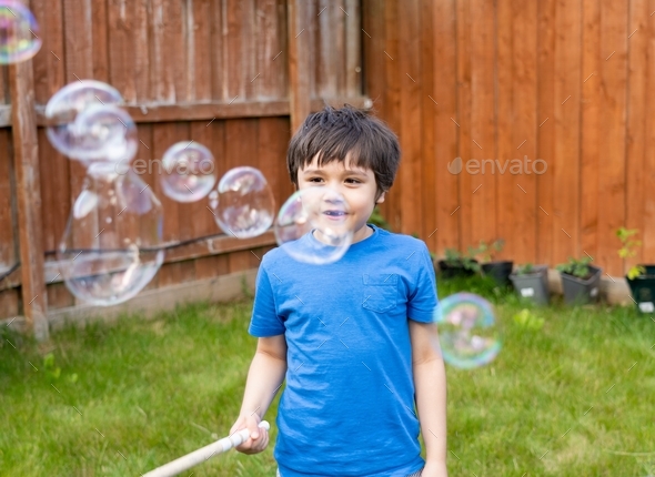 Kid chasing and playing with soap bubbles in garden, Funny Child ...