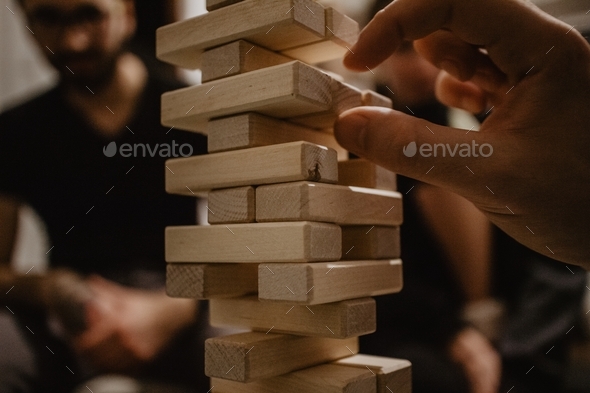 Millennials playing a board game Jenga / night fun / groups of people ...