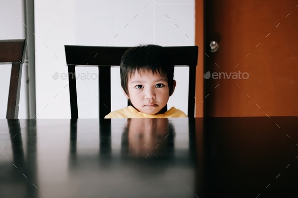 Image of young kid staring at you with reflection her face on table ...