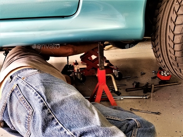 Auto Mechanics! A man working under his car. Garage Mechanics! Stock ...