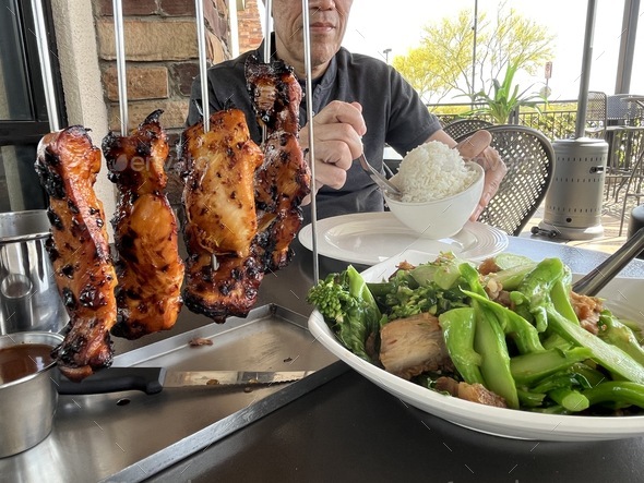Man eating at an Asian restaurant at lunch time Stock Photo by langalvezjen