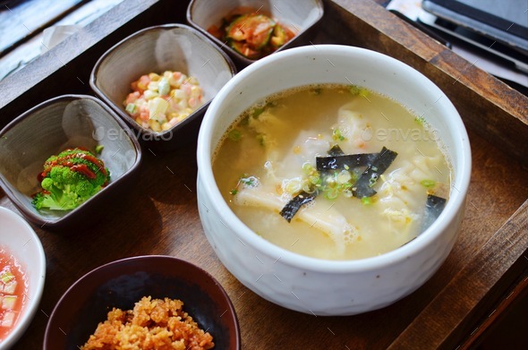 Korean rice dumpling soup Duk Mandy Guk with banchan vegetables on the ...