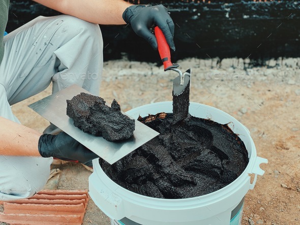 Priming solid bricks with bitumen primer Stock Photo by VforVictoria