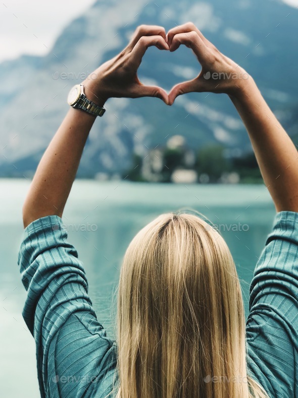 Rear view of blonde woman forming heart shape Stock Photo by VforVictoria